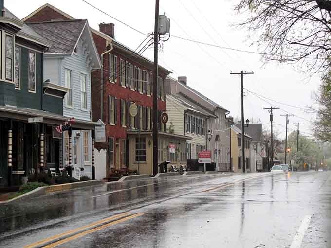 Rain-slicked streets reflect the historic buildings, adding a moody atmosphere to this perfectly preserved main street scene.