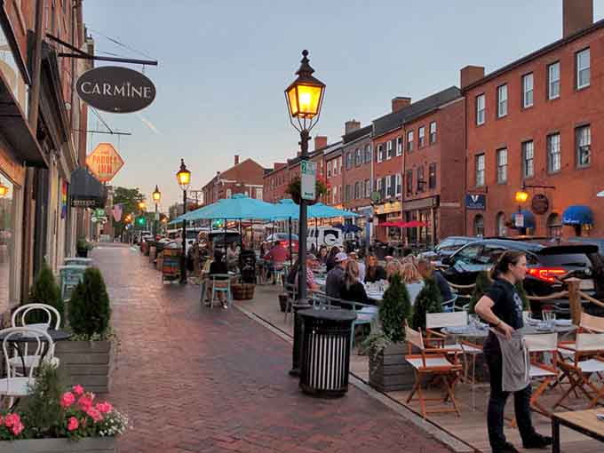 Gas lamps glow as outdoor diners settle in for sunset dining that beats any chain restaurant experience.