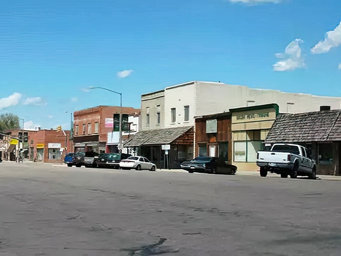 Wide streets and dramatic clouds create that classic High Plains atmosphere where the sky dominates everything beneath it magnificently.