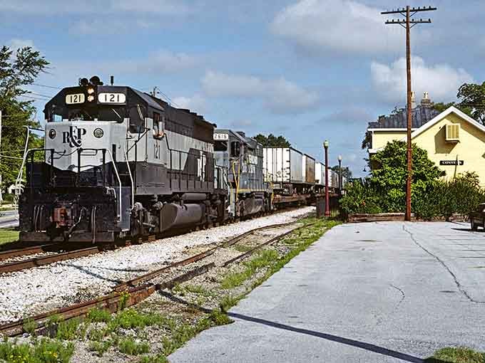 A freight train powers through town, proving these aren't museum pieces but working rails connecting real communities today.