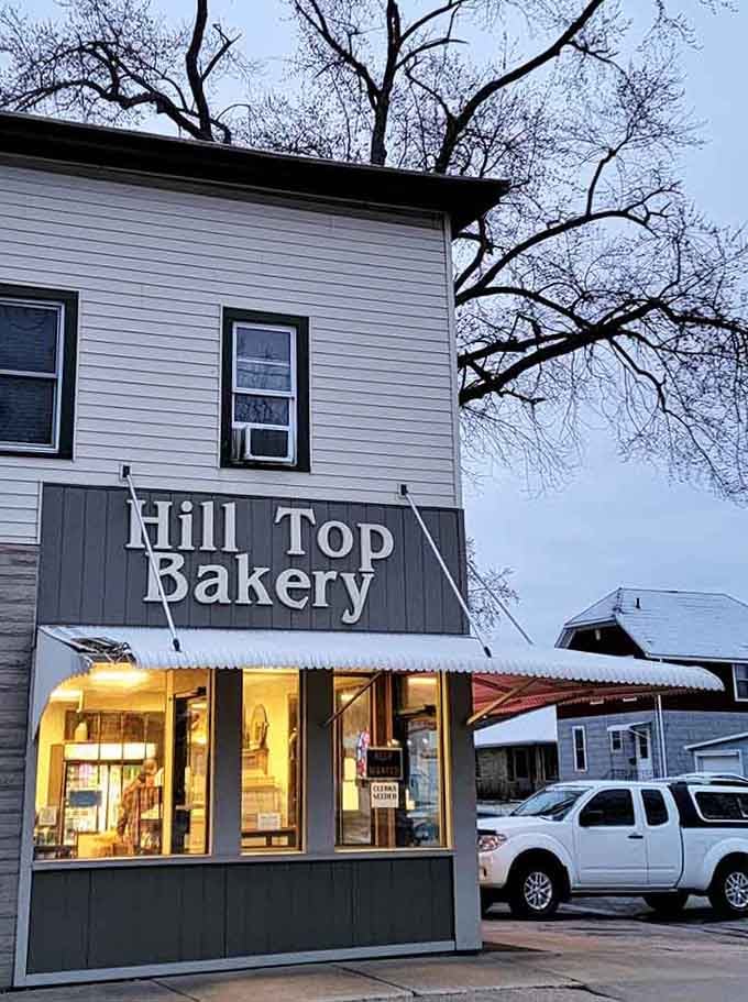 Golden light spills from the windows like a warm invitation, promising fresh-baked comfort on even the coldest Wisconsin evenings.