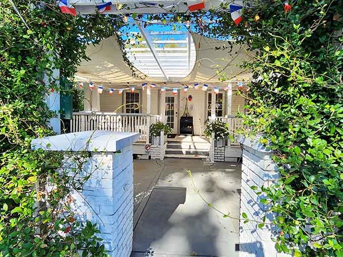 The vine-covered pergola frames this inviting space like a postcard from Provence you can actually visit.