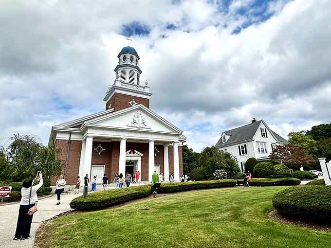 That steeple reaches toward dramatic clouds, anchoring a town green where ordinary farmers became extraordinary heroes in 1775.