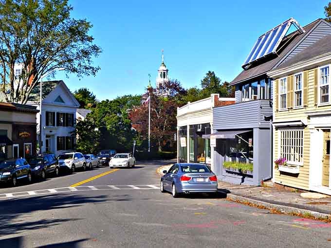 White steeples peek through autumn leaves on roads where New England tradition feels refreshingly alive and welcoming.