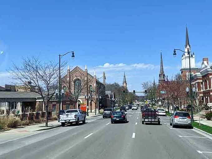 Church spires punctuating the skyline remind you that some towns still build things meant to last generations.