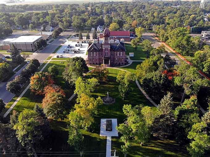 The bird's-eye view reveals a masterpiece of civic pride nestled among trees that have witnessed generations of community gatherings.
