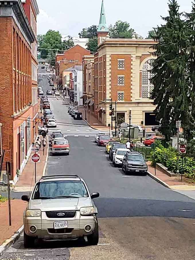 The way this street slopes downward reveals brick facades, parked cars, and a historic church&mdash;stacked like a perfectly composed photograph.