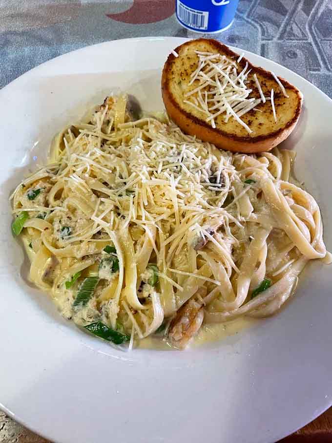 Creamy Alfredo sauce coating tender seafood and pasta creates comfort food magic on a plate.