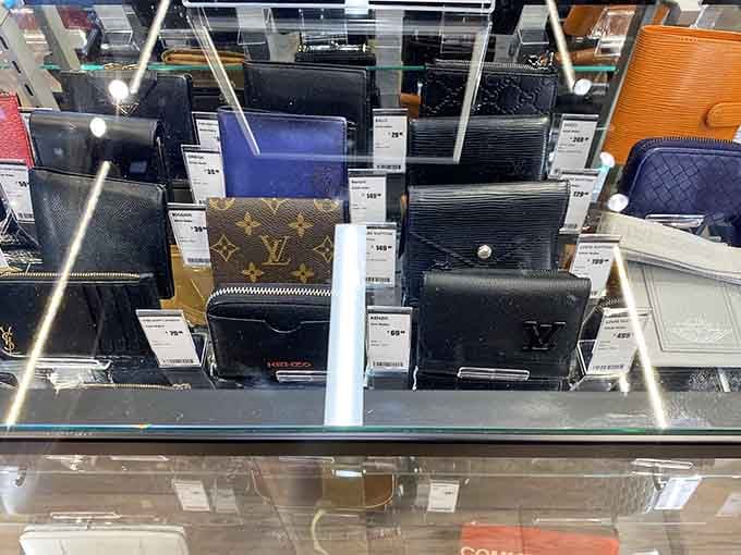 Designer wallets behind glass proving that luxury doesn't always require selling your firstborn child to afford it.