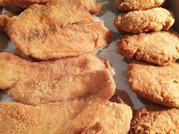 Perfectly fried fish options lined up like edible treasure, each piece promising flaky, seasoned satisfaction with every bite.