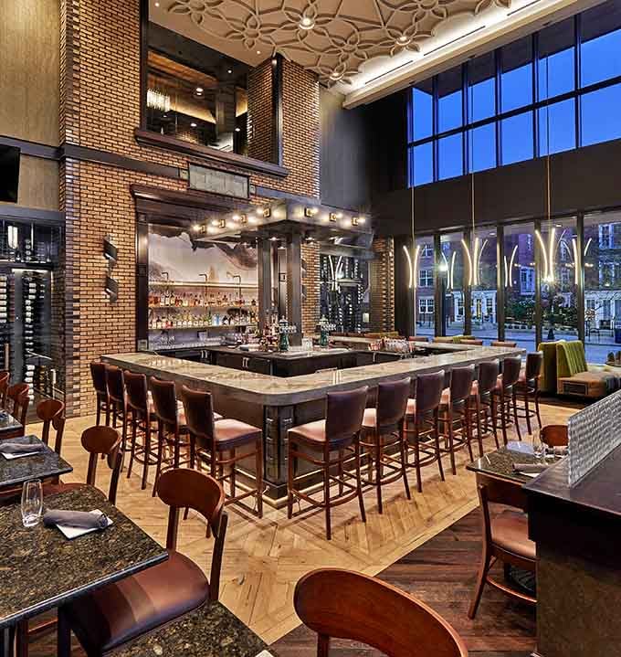 The bar area combines soaring ceilings with cozy seating, making every cocktail feel like an event.