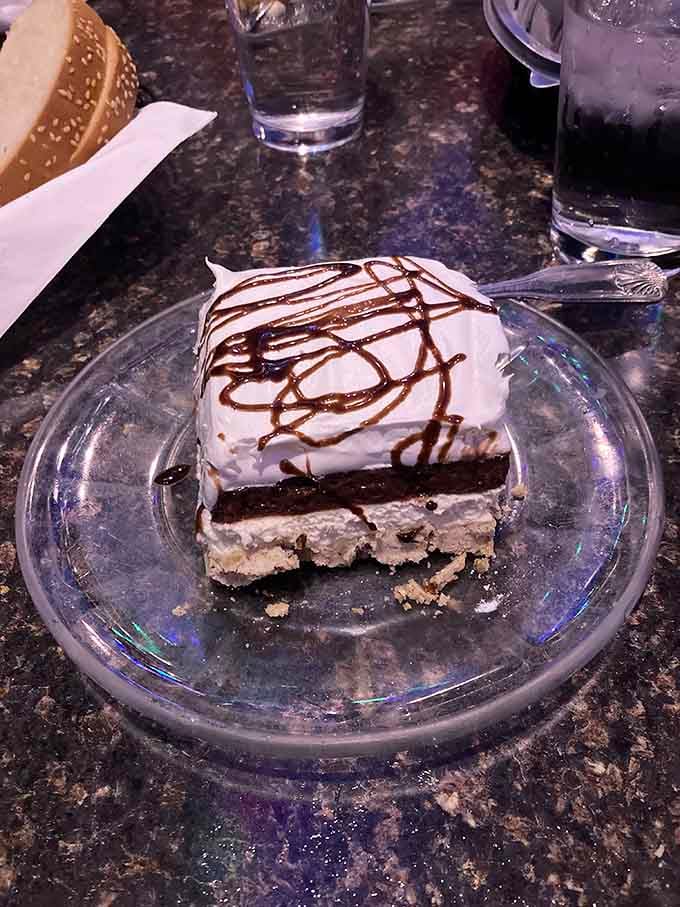 Four glorious layers of pecan crust, cream cheese, chocolate pudding, and whipped cream towering like edible architecture.