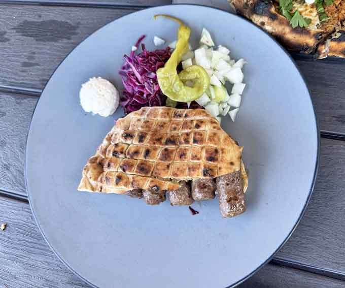 The cevapi platter showcases those famous grilled sausages alongside vibrant purple cabbage, proving food can be both beautiful and delicious simultaneously.