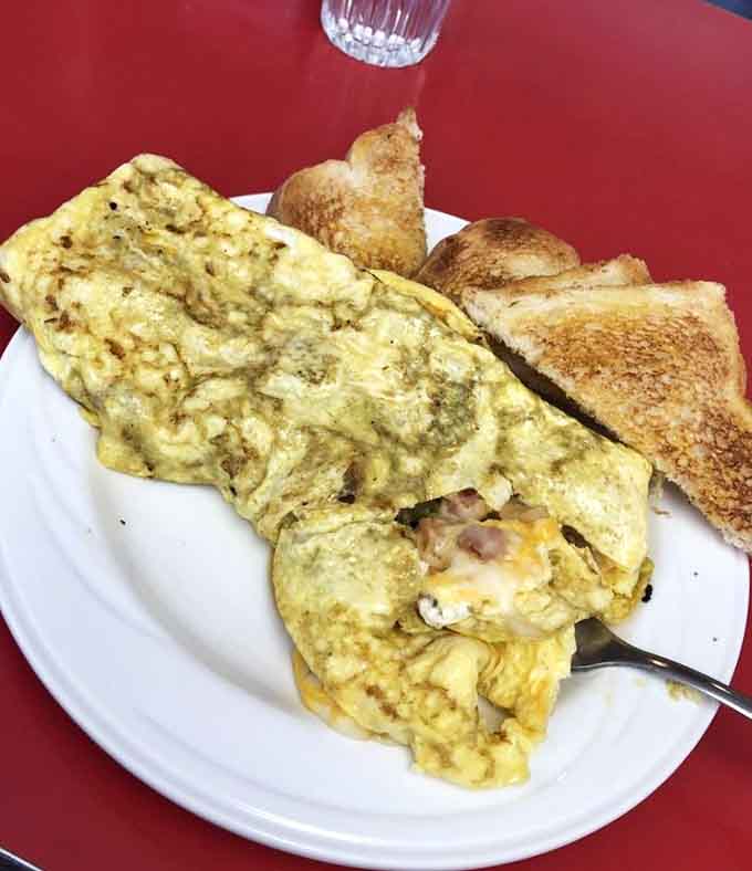 That omelet is stuffed with cheese and meat, folded with the kind of skill that only comes from practice.