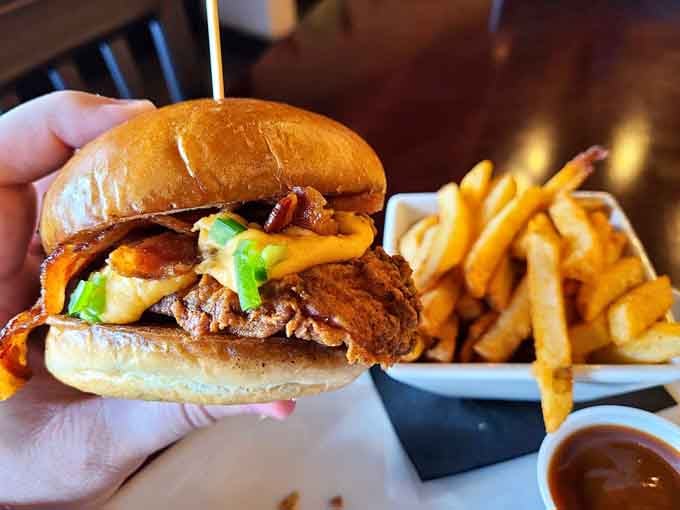 This burger stacks high with bacon and all the fixings, requiring strategic planning just to take a bite.