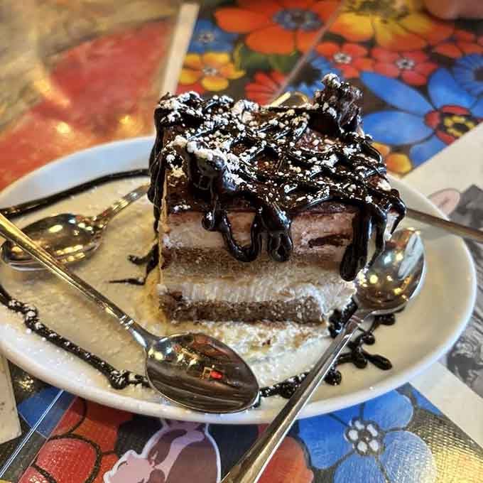 This towering tiramisu slice drizzled with chocolate sauce looks like it belongs in a dessert hall of fame.