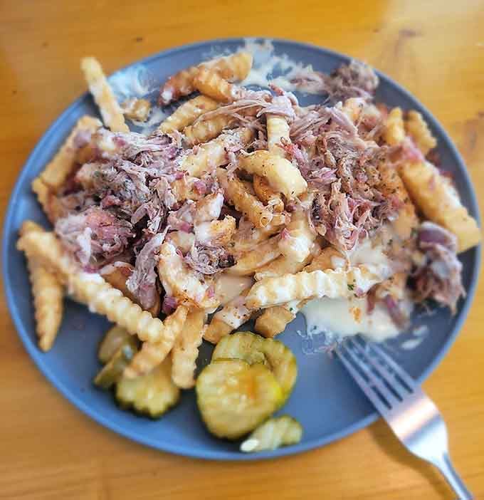 Pulled pork over fries with pickles is the kind of genius mashup that should win culinary awards immediately.