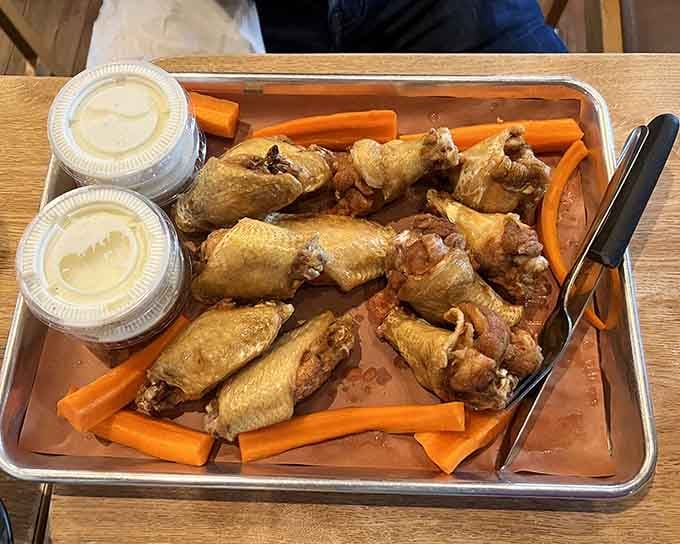 Golden wings surrounded by carrot sticks, because even barbecue joints know you need vegetables to justify ordering twenty-four wings.