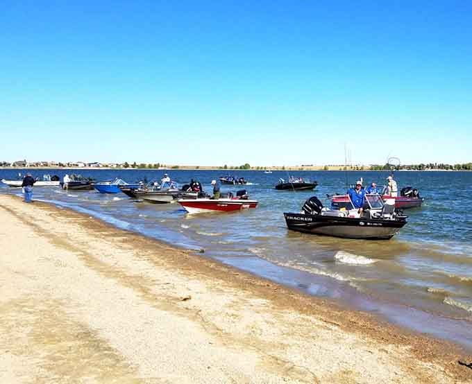 Fishing boats line the shore like a marina convention, proving this lake serves multiple summer passions beautifully.