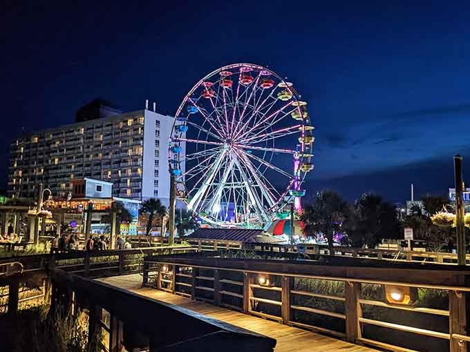 The Ferris wheel glows like a jewel against twilight skies, transforming the boardwalk into pure coastal magic after dark.
