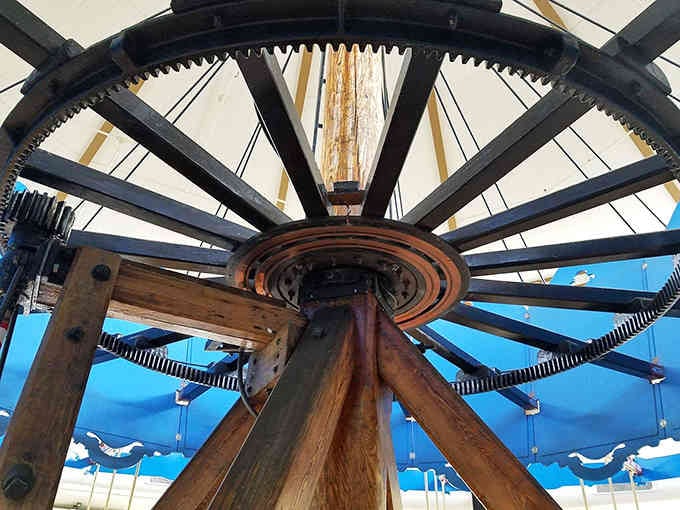 The exposed gears and mechanisms reveal the engineering marvel that keeps this century-old machine spinning smoothly.