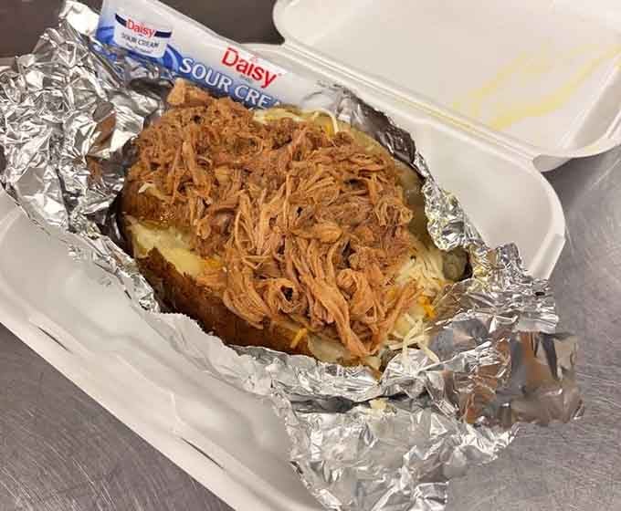 Behold the loaded potato that decided to go all-in, topped with pulled pork and enough cheese to make you smile.