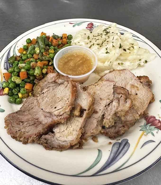 Tender sliced pork roast with creamy mashed potatoes and colorful vegetables looks like Sunday dinner at grandma's house.