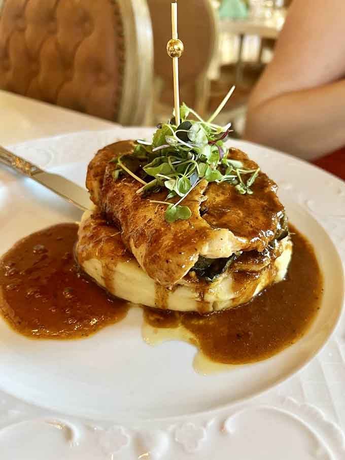 Stacked chicken with sauce drizzle looking like it graduated from culinary school with honors and excellent table manners.