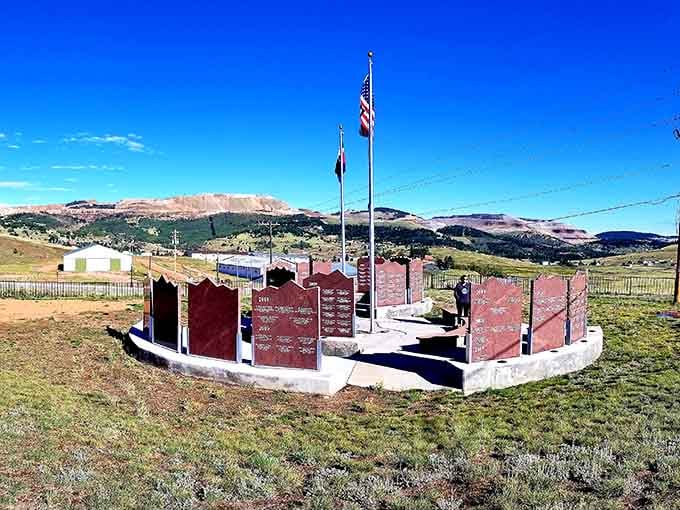 Red granite monuments stand against endless sky, honoring the miners who built this improbable mountain town one strike at a time.