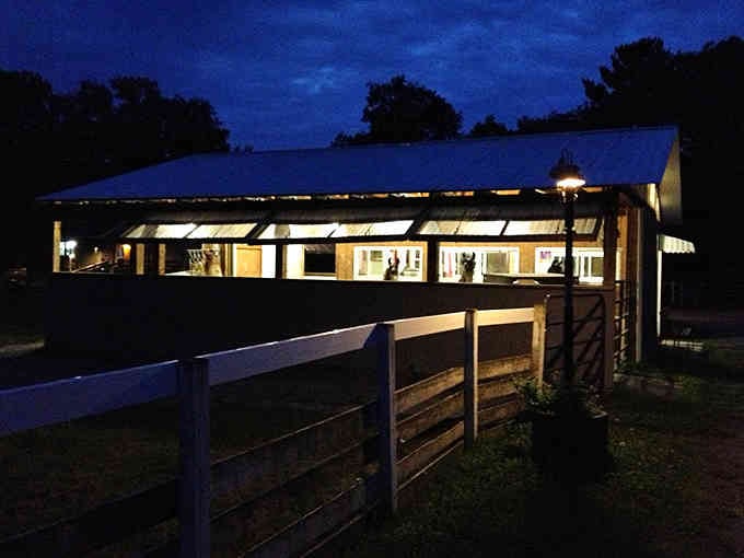 Even after sunset, the barn glows with warmth, suggesting these llamas have better accommodations than most college students do.