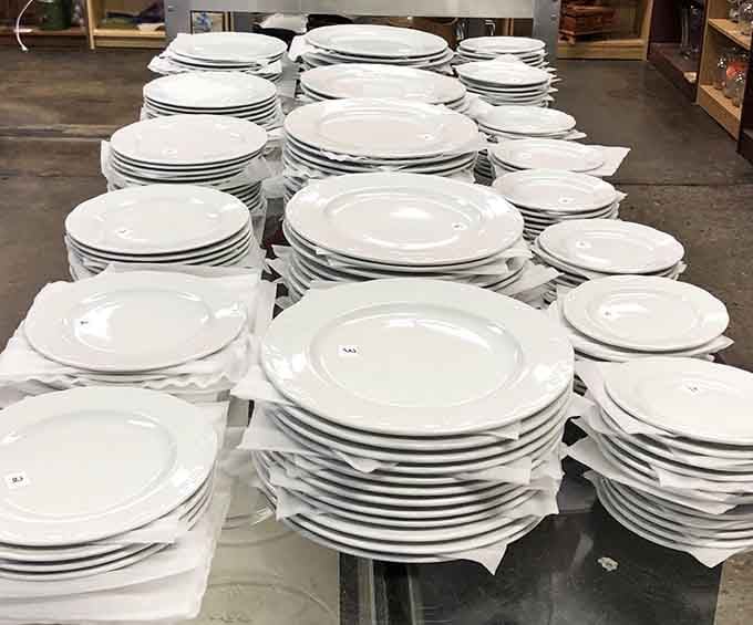 Enough white plates to host every potluck in Richmond, stacked like porcelain skyscrapers.