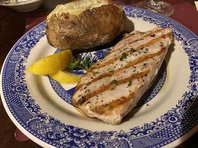 Perfectly grilled fish with a golden potato that looks like it graduated from culinary school with honors.
