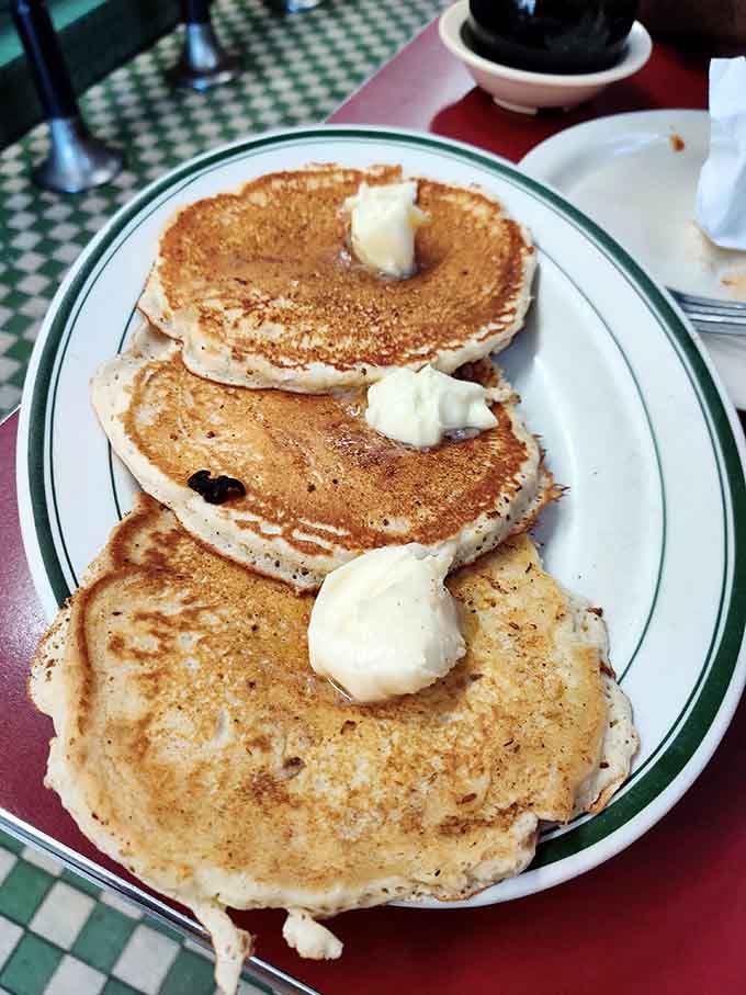 Golden pancakes stacked high with butter pats melting down remind us this place serves breakfast dreams before the lunch rush begins.