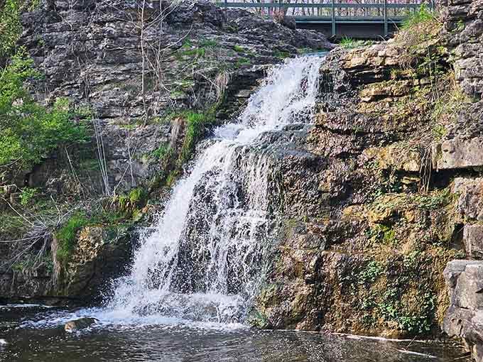 The waterfall cascades over ancient limestone like it's been doing this forever, because honestly, it basically has.