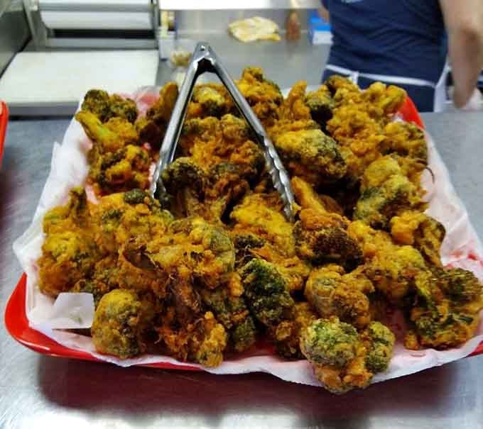 Fried broccoli piled high like golden nuggets of vegetable redemption, proving that everything's better when it's breaded and crispy.