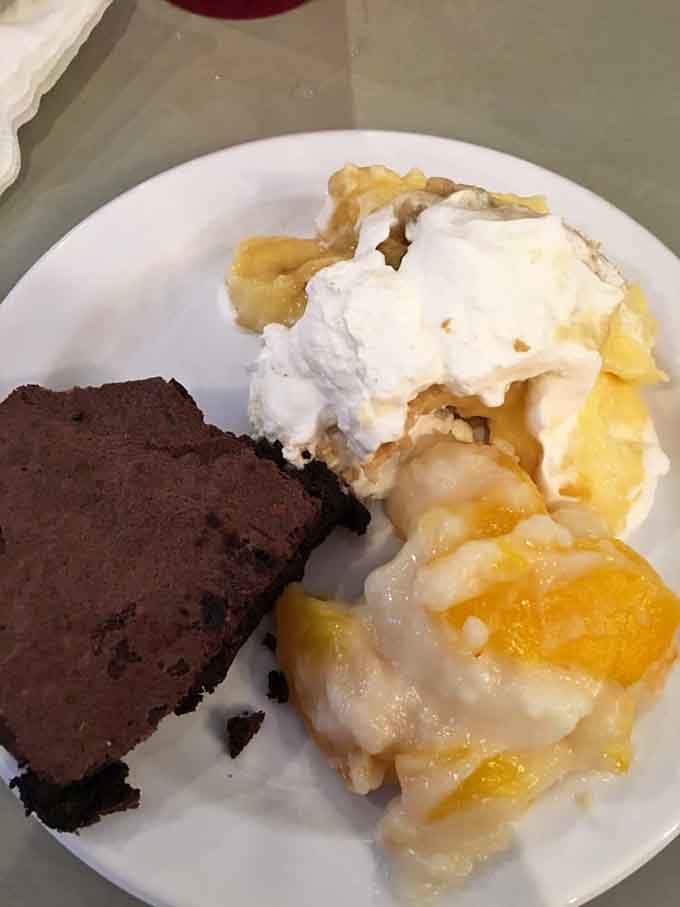 A dessert plate featuring brownies, peach cobbler, and banana pudding&mdash;basically the Holy Trinity of Southern sweet endings.