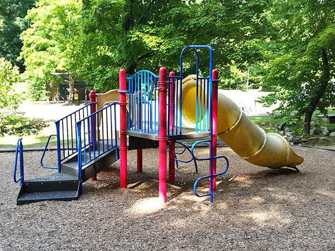 That twisty slide promises thrills for kids while parents enjoy the shade and a well-deserved breather nearby.