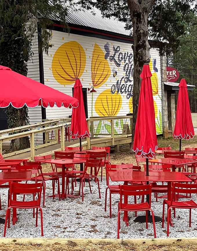 Bright red outdoor seating under cheerful umbrellas, where "Love Your Neighbor" isn't just painted, it's practiced daily.