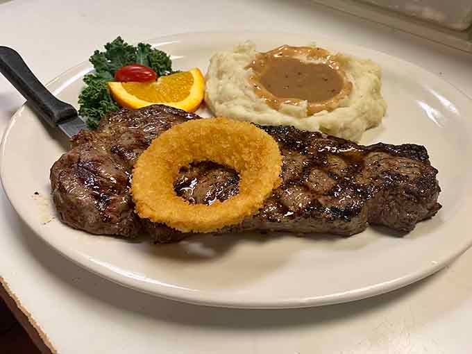 A rib eye steak for breakfast feels rebellious in the best possible way, especially with that onion ring crown.