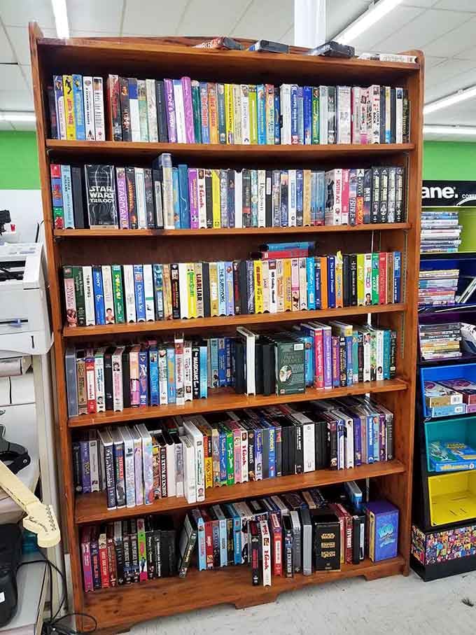 A bookshelf packed with VHS tapes and DVDs for those who appreciate physical media and nostalgic movie nights.