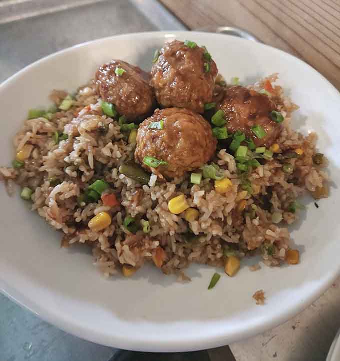 Meatballs over fried rice with vegetables, because sometimes fusion food just makes sense and tastes even better than it sounds.