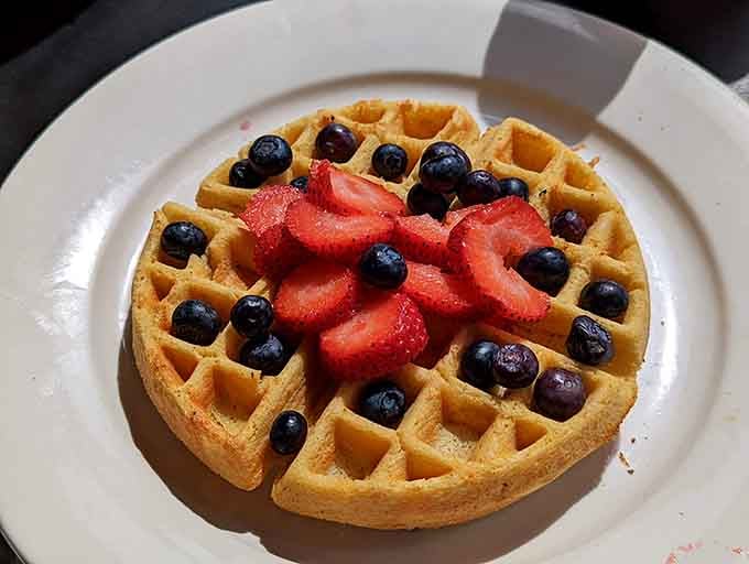 A waffle crowned with fresh berries that looks almost too pretty to eat. Almost being the key word.