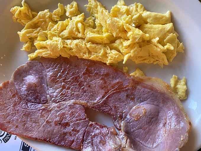 Country ham and eggs proving that sometimes the simplest combinations create the most satisfying breakfast symphonies imaginable.