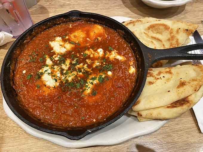 Shakshuka arrives in a skillet like it's auditioning for a cooking show, and it's getting the part.