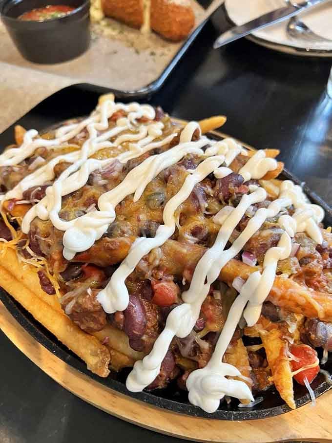 Loaded fries drizzled with sauce and piled high with toppings transform a simple side into a meal worth sharing, or not.