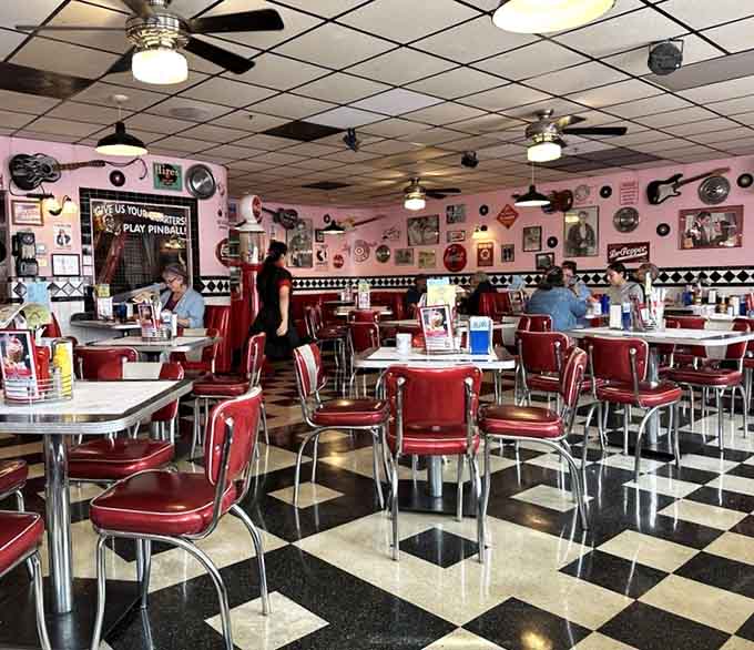 Pink walls and vintage memorabilia surround diners enjoying their meals in authentic 1950s splendor and comfort.