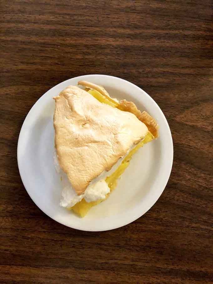 Lemon meringue pie standing tall and proud, ready to brighten your day one tangy bite at a time.