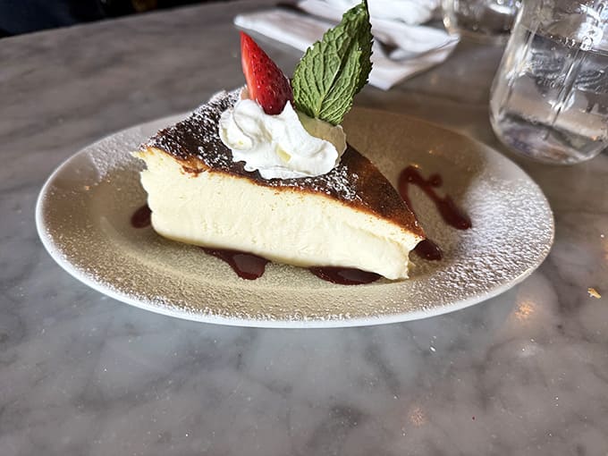 Silky cheesecake that wobbles just right, topped with whipped cream and a mint leaf for that grandmother's touch.