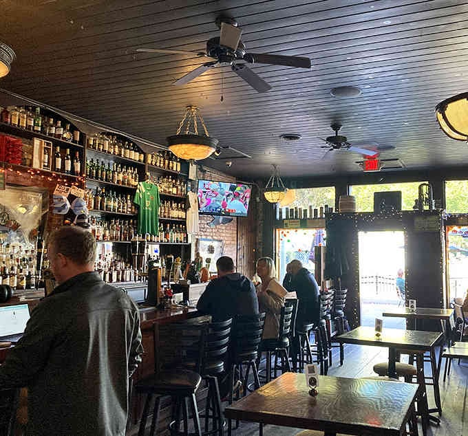 Ceiling fans spinning lazily overhead while patrons gather at the bar captures that timeless pub atmosphere perfectly.