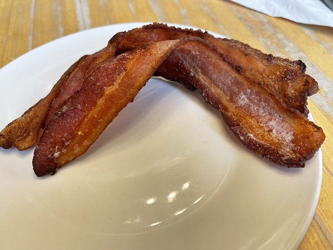 Two strips of perfectly cooked bacon, crispy enough to stand at attention, ready to make any breakfast plate complete and happy.